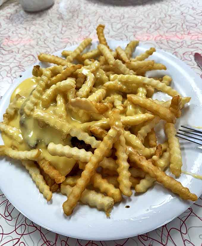 Cheese fries worth the trip: Crinkle-cut potatoes wearing a molten cheese blanket &ndash; the kind of side dish that accidentally becomes the main event.