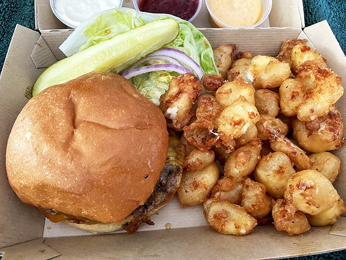 The perfect pairing: a juicy burger alongside those famous cheese curds &ndash; comfort food nirvana on a single tray.