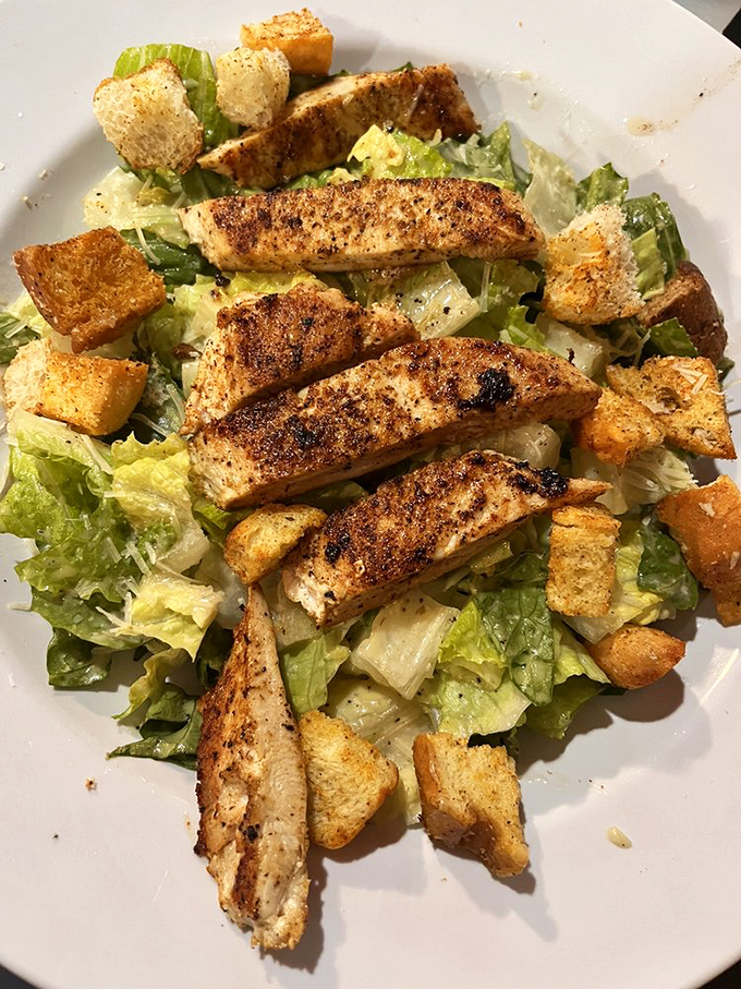 A Caesar salad that actually delivers on its promises &ndash; crisp romaine, perfectly seasoned chicken, and croutons that shatter with satisfying crunch.