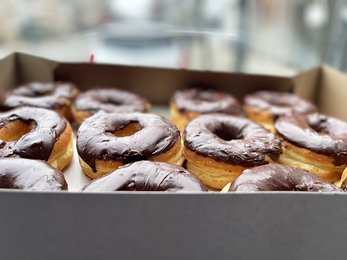 Chocolate glazed donuts lined up like edible soldiers, their glossy tops promising the perfect balance of sweetness and rich cocoa flavor.