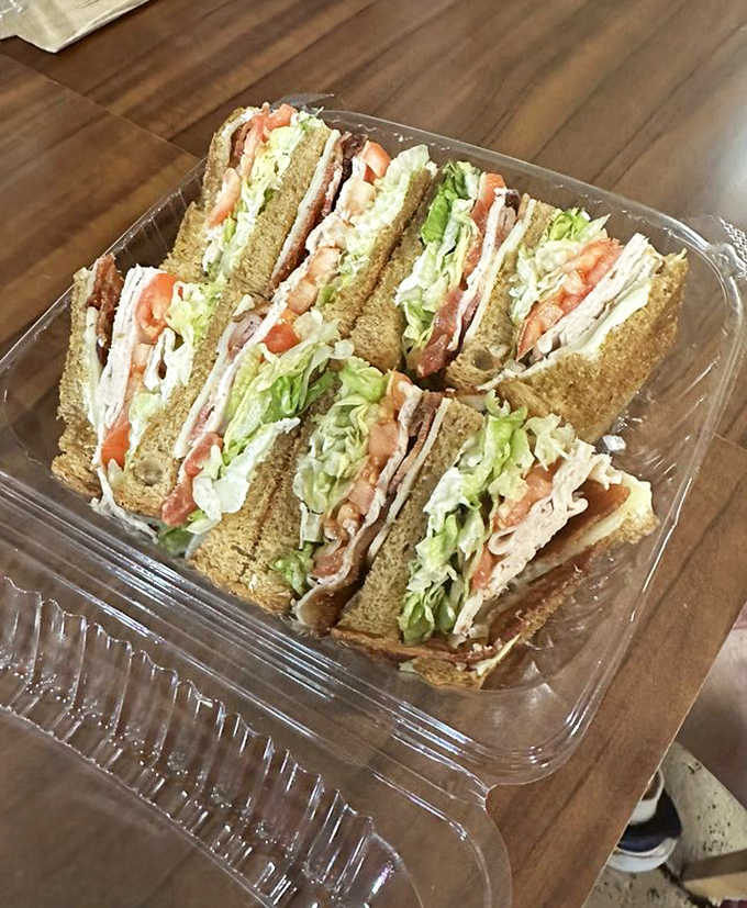 The club sandwich arrives properly constructed in neat quarters, layers of turkey and bacon stacked with the precision of someone who's made about ten thousand of these.