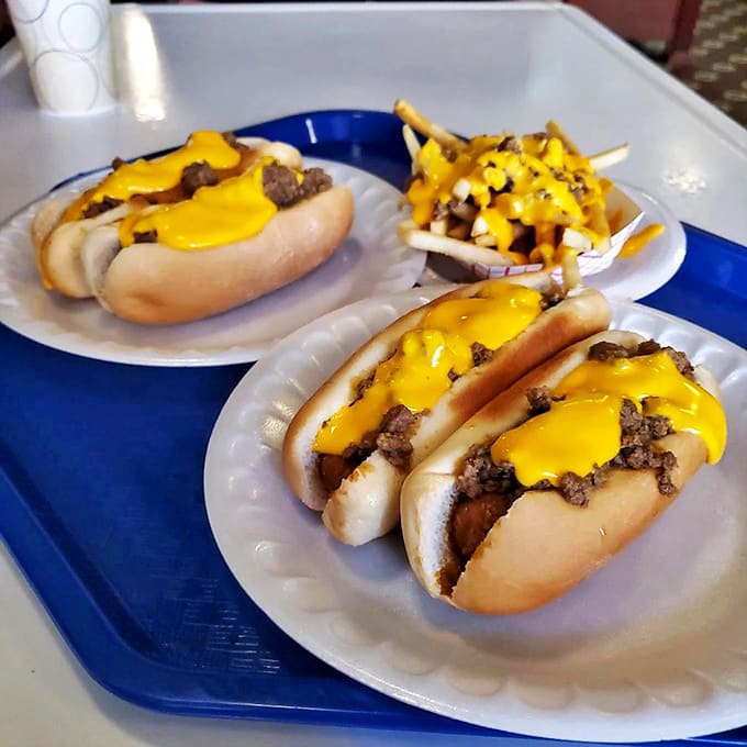 Coney dogs done right &ndash; snappy franks nestled in soft buns, smothered with savory meat sauce and crowned with melted cheese that creates pure Midwestern comfort on a plate.