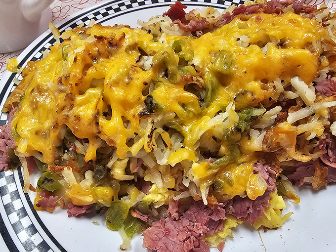 Breakfast alchemy: corned beef hash and eggs unite in perfect harmony, topped with melted cheese that stretches with each heavenly forkful.