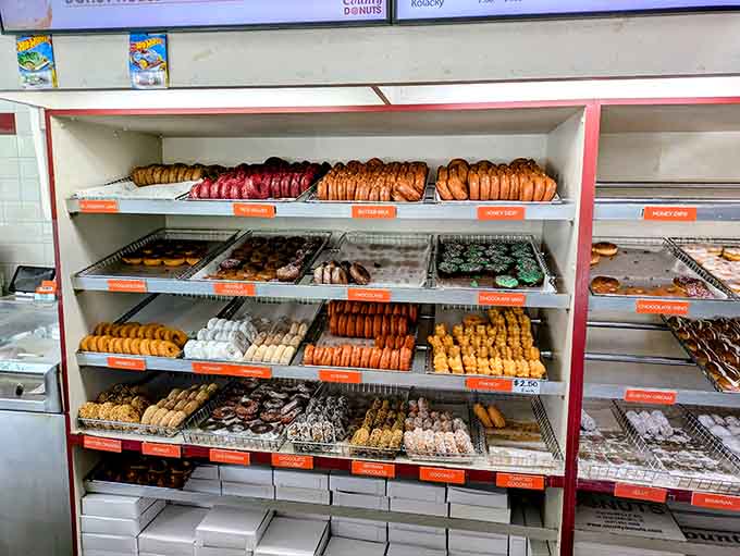 Rows of fresh donuts await their destiny, each one handcrafted and ready to make someone's day infinitely better than it was five minutes ago.