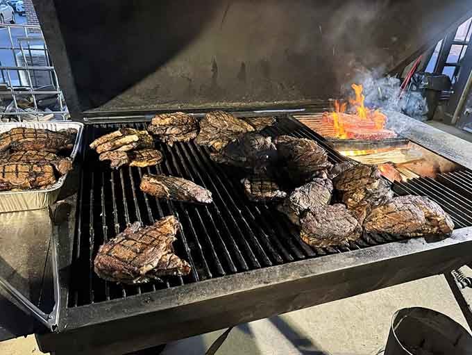 The flames licking those steaks are doing the Lord's work, creating the kind of crust that makes grown adults weep with anticipatory joy.