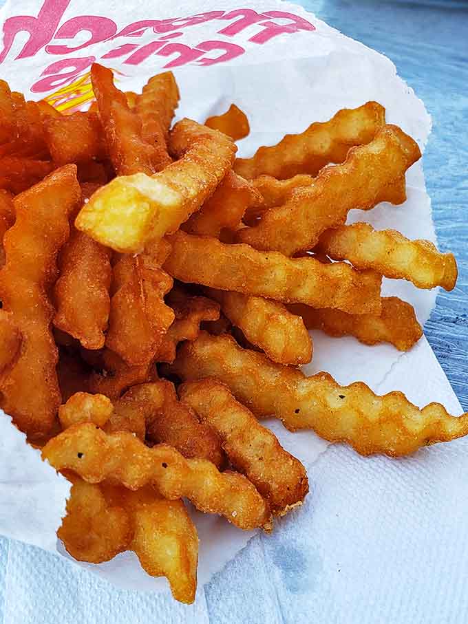 These aren't just any crinkle-cut fries &ndash; they're golden tickets to potato paradise, crispy on the outside and fluffy within.