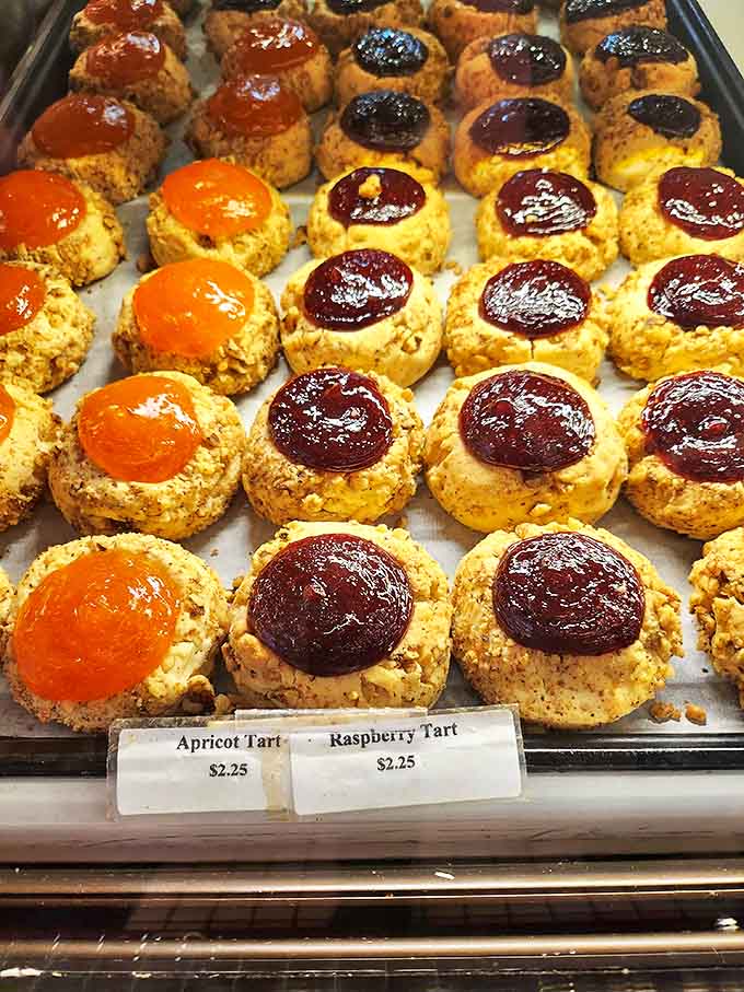 These fruit tarts aren't just desserts; they're jewel boxes where apricot and raspberry treasures nestle in shortbread settings, waiting to be discovered.