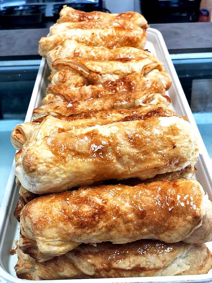 These glistening pastry rolls aren't just baked &ndash; they're caramelized to perfection, each one a sticky, sweet work of art.