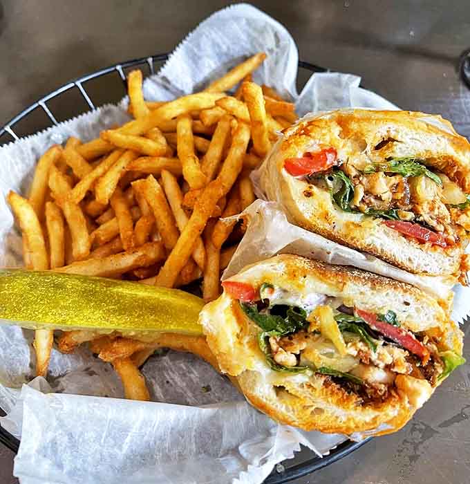 This Jerk Chicken Po' Boy sandwich brings Caribbean heat to Michigan shores, nestled alongside golden fries that demand to be devoured immediately.