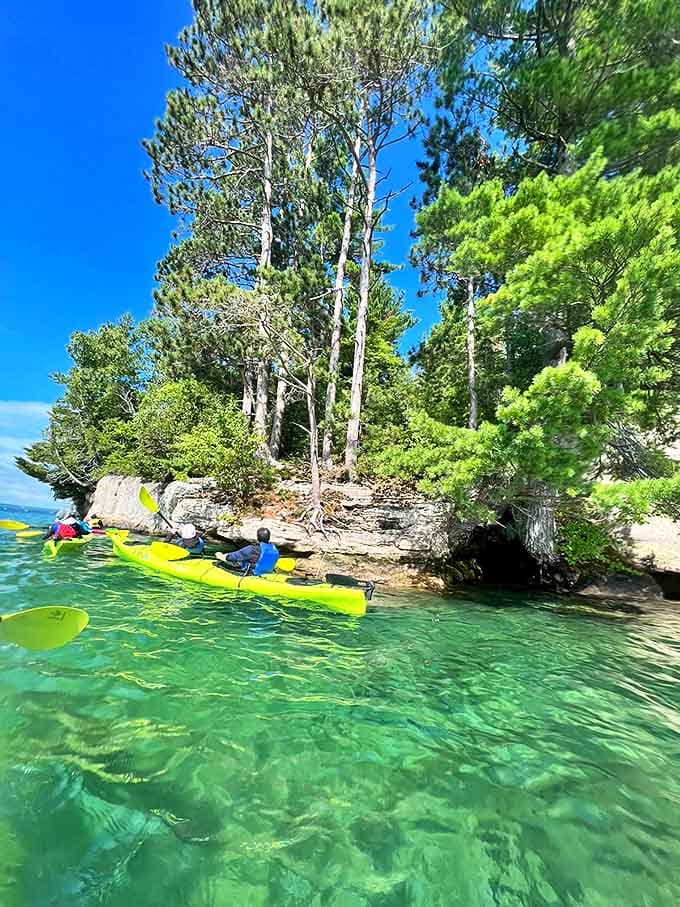 Kayakers glide through emerald waters so clear you'll wonder if you're in the Caribbean instead of the Upper Peninsula.