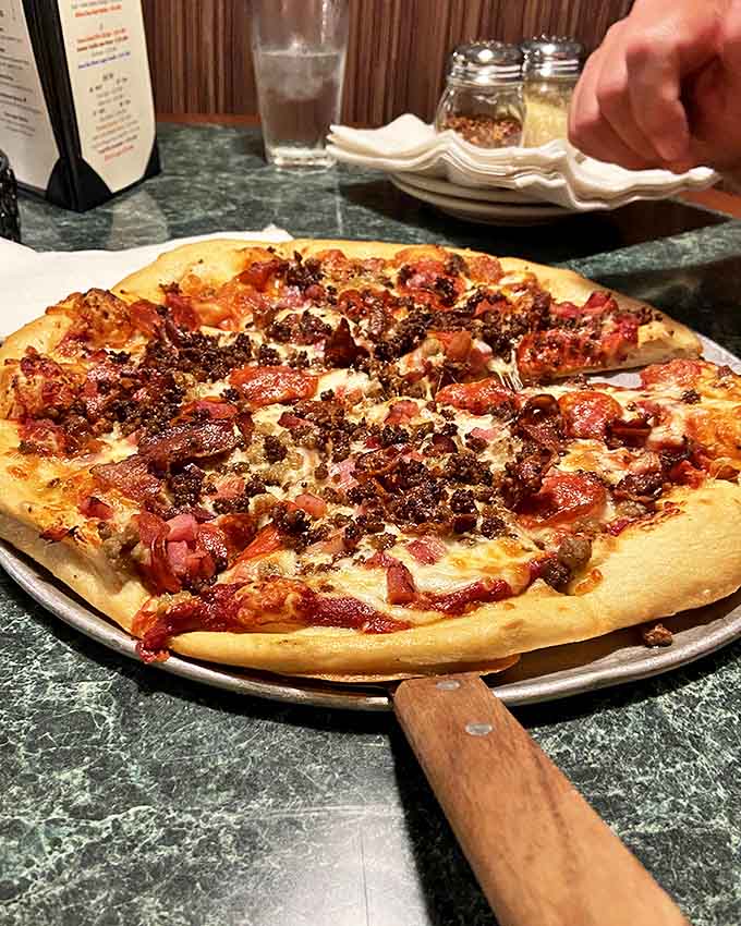 A carnivore's dream come true &ndash; this pizza doesn't just have toppings, it has a meaty celebration under a blanket of melted cheese.