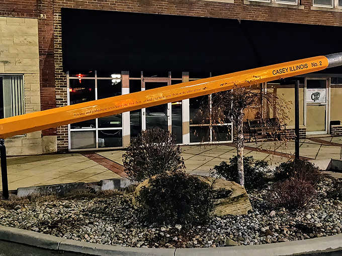 Even after sunset, the giant pencil stands sentinel over Casey's quiet streets, illuminated against the night sky.