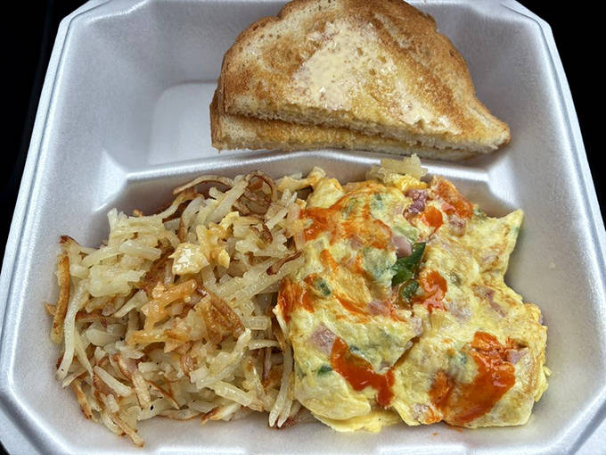 The omelet arrives like a colorful patchwork quilt of vegetables and cheese, accompanied by hash browns with that magical crispy-outside, tender-inside duality.