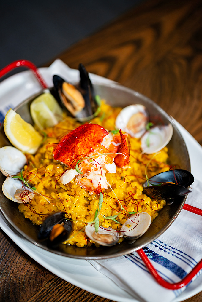 Paella: Saffron-stained rice cradles seafood treasures like a Caribbean sunset captured in a pan &ndash; no passport required.
