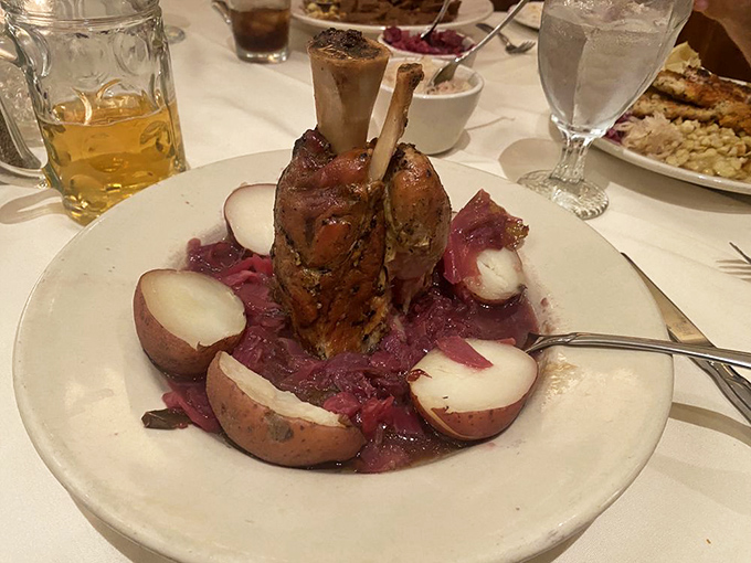Pork shank rising majestically from a bed of sauerkraut and potatoes, like a meaty monument to German culinary tradition.