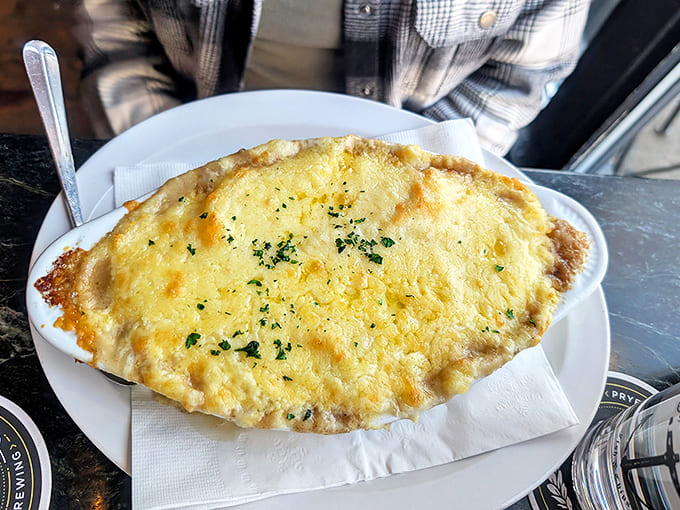 Steam rises from this freshly-served Shepherd's Pie, its golden potato topping hiding treasures of savory filling below.