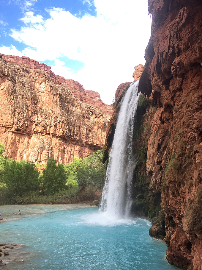 Dramatic plunge: Water free-falls from the canyon edge, creating a natural shower that's worth every step of the journey.