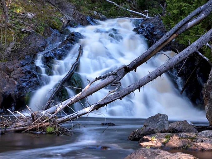 The hypnotic flow of Pinnacle Falls mesmerizes visitors, its constant motion paradoxically creating a sense of perfect stillness within.