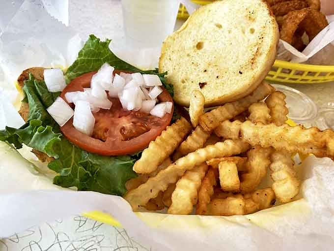 Fresh lettuce, ripe tomato, and crispy fries accompany a sandwich that proves simple ingredients, prepared with care, create the most satisfying meals.