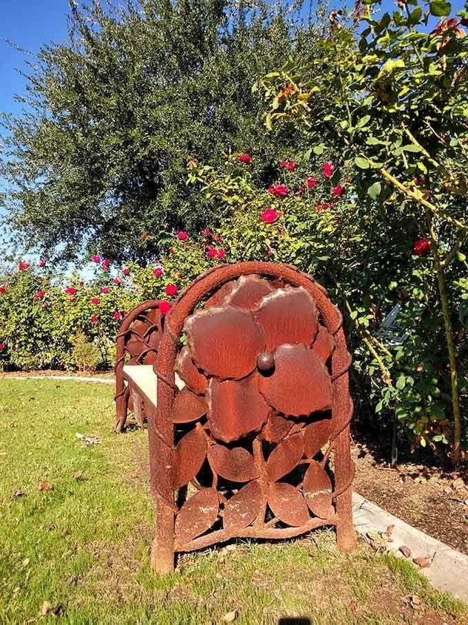 Even the benches get the rose treatment here, with rusted metal blooms offering a permanent perch among their living cousins.