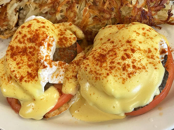 Eggs Benedict elevated to art form: poached eggs perched atop English muffins, blanketed in hollandaise and sprinkled with paprika like edible sunshine.