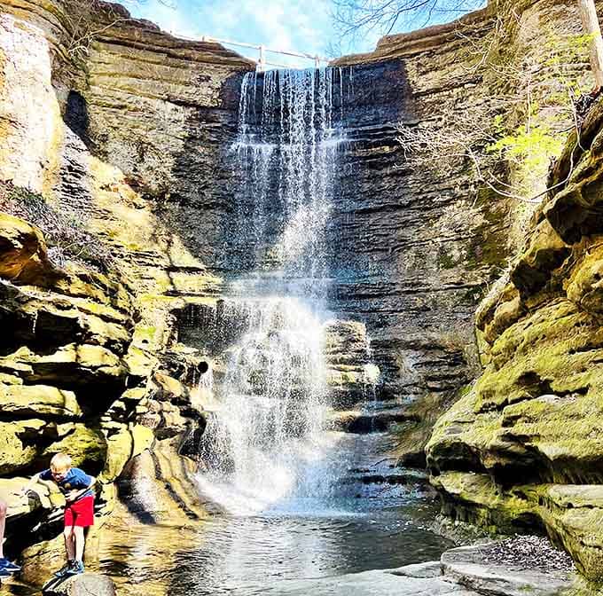 Scale brings perspective: A visitor admires the towering waterfall, reminding us how small we are in nature's grand design.