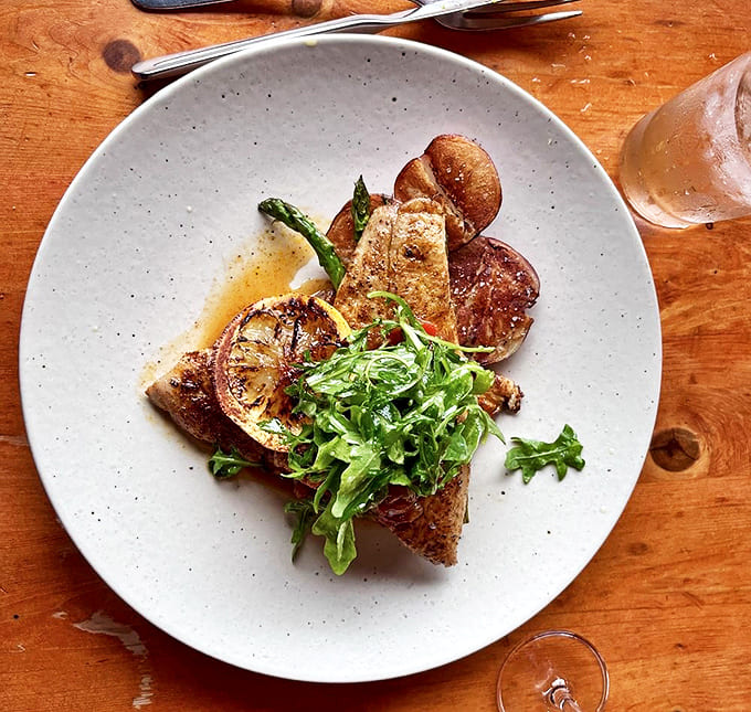 Delicate whitefish gets the star treatment with charred lemon and fresh greens &ndash; proof that Fitzgerald's magic extends well beyond barbecue.