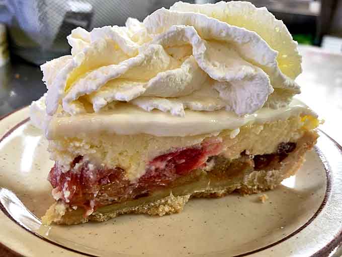 Each bite reveals the perfect harmony of textures &ndash; flaky crust, tender rhubarb, and that cloud of whipped cream slowly melting into warm filling.