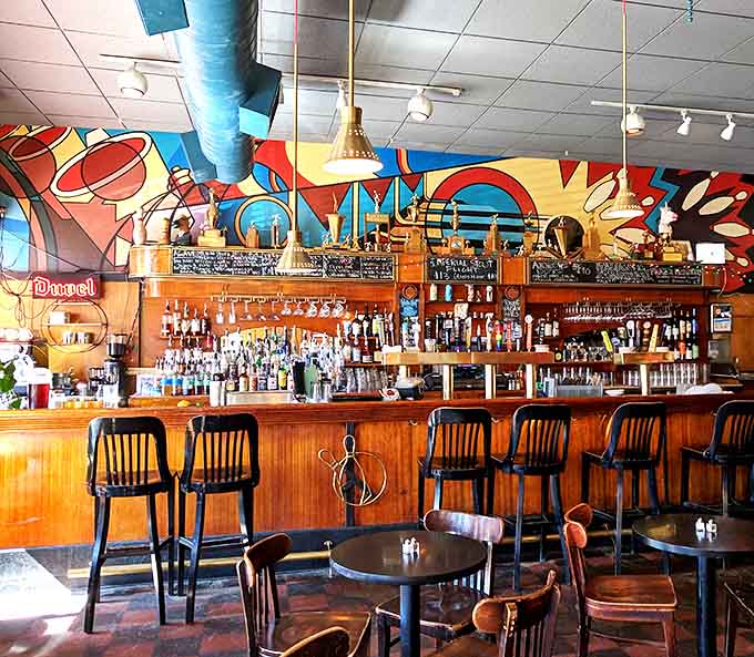 The bar's vibrant mural provides a colorful backdrop for craft cocktails and conversations that flow as smoothly as the drinks.