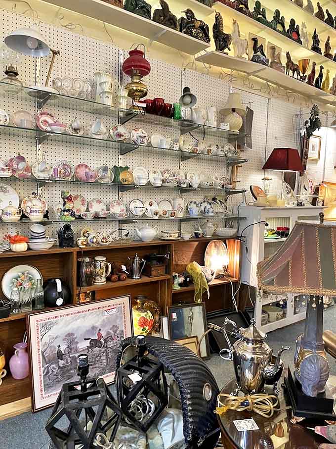 Delicate teacups and saucers line the shelves like silent witnesses to countless conversations, each pattern telling its own story of bygone elegance.