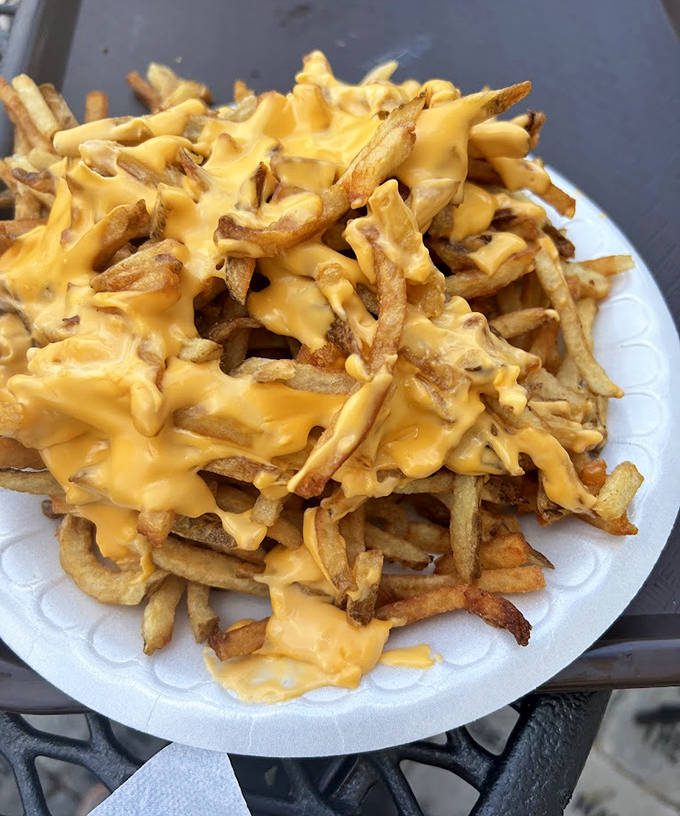 Golden hand-cut fries disappear under a lava flow of cheese sauce &ndash; a side dish that frequently steals the spotlight from its frankfurter companions.