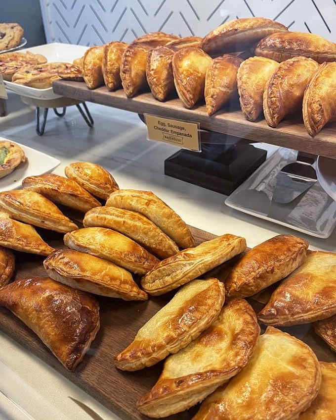 A wooden board showcasing the day's empanada varieties. Like a pastry runway where each model is more delicious than the last.