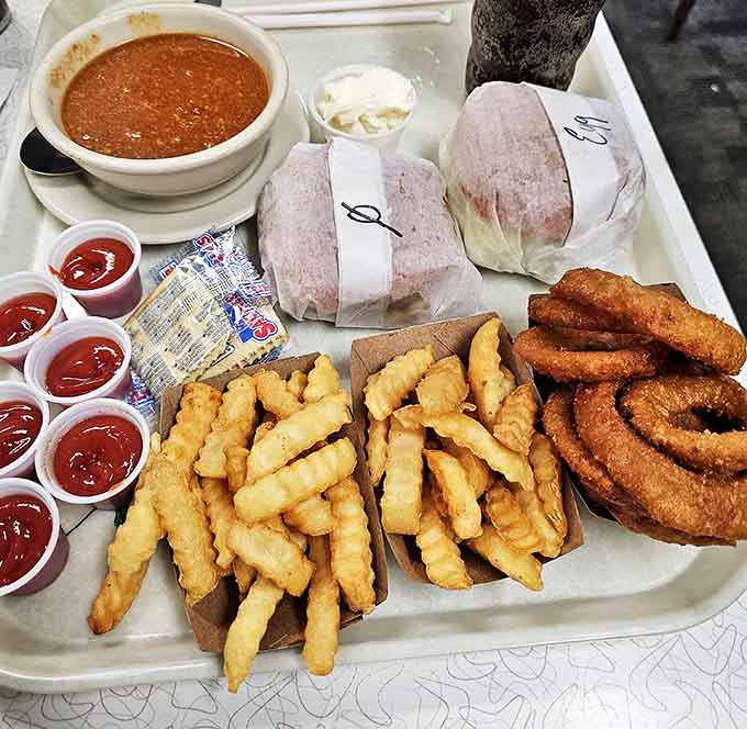 A tray that whispers "cardiac concern" but shouts "worth it!" &ndash; crispy fries, onion rings, and wrapped burgers waiting for their moment.