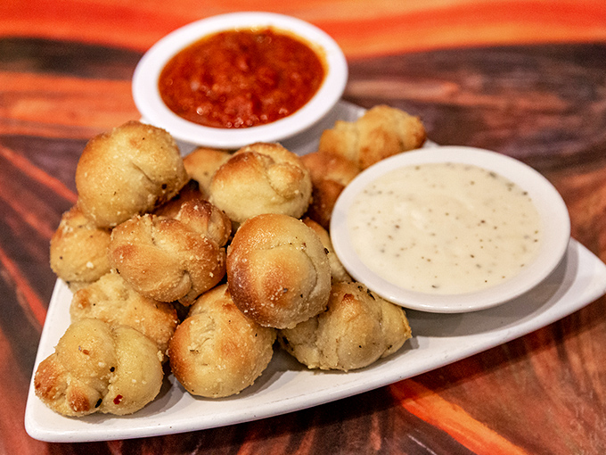 These garlic knots aren't just appetizers &ndash; they're bite-sized sculptures of doughy perfection, glistening with buttery, garlicky goodness.