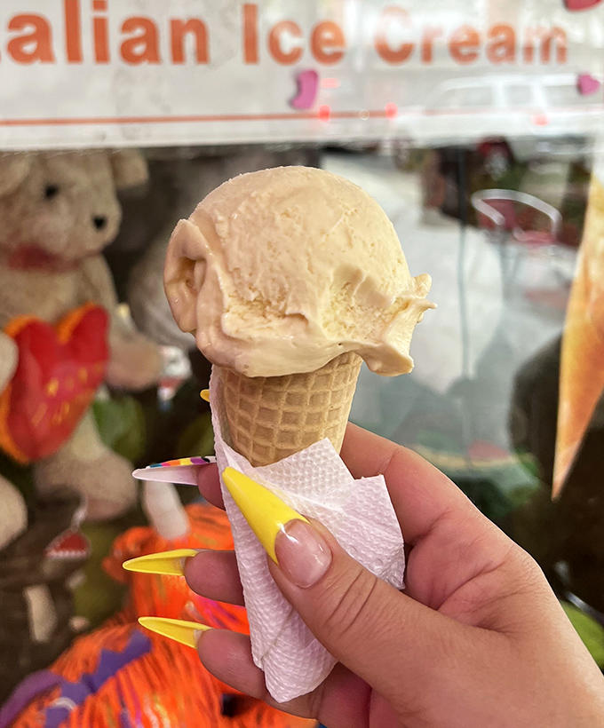 A perfectly formed scoop of gelato perches atop a fresh waffle cone, the quintessential handheld happiness that demands to be savored slowly.