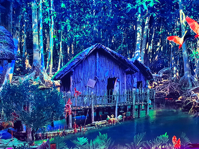 A glowing jungle hut emerges from the mist, its blue-tinged surroundings creating the perfect backdrop for mini-golf mythology.