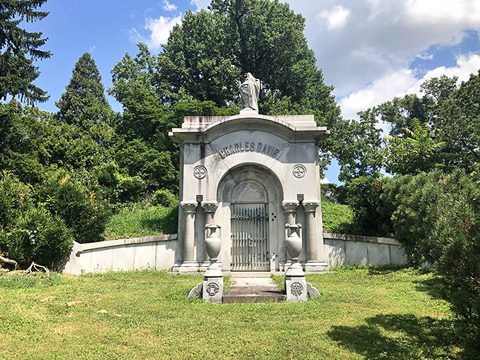 The Charles Davis mausoleum stands like a miniature classical temple, its pristine columns gleaming against the verdant backdrop.