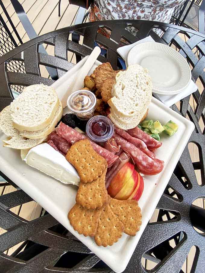 This isn't just lunch – it's an edible still life painting featuring local cheeses, cured meats, and fresh fruit.