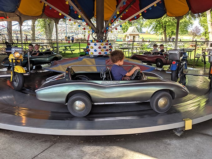 Pint-sized drivers take the wheel in vintage-style cars, their faces a perfect picture of concentration as they navigate the circular track.
