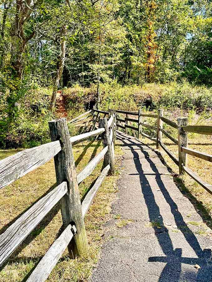A rustic wooden walkway guides modern explorers through history, the weathered fence a gentle reminder to respect these industrial artifacts.