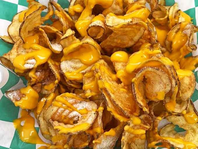 Tornado potatoes meet cheese sauce in this beautiful union, creating the kind of loaded fries that require strategic napkin placement.