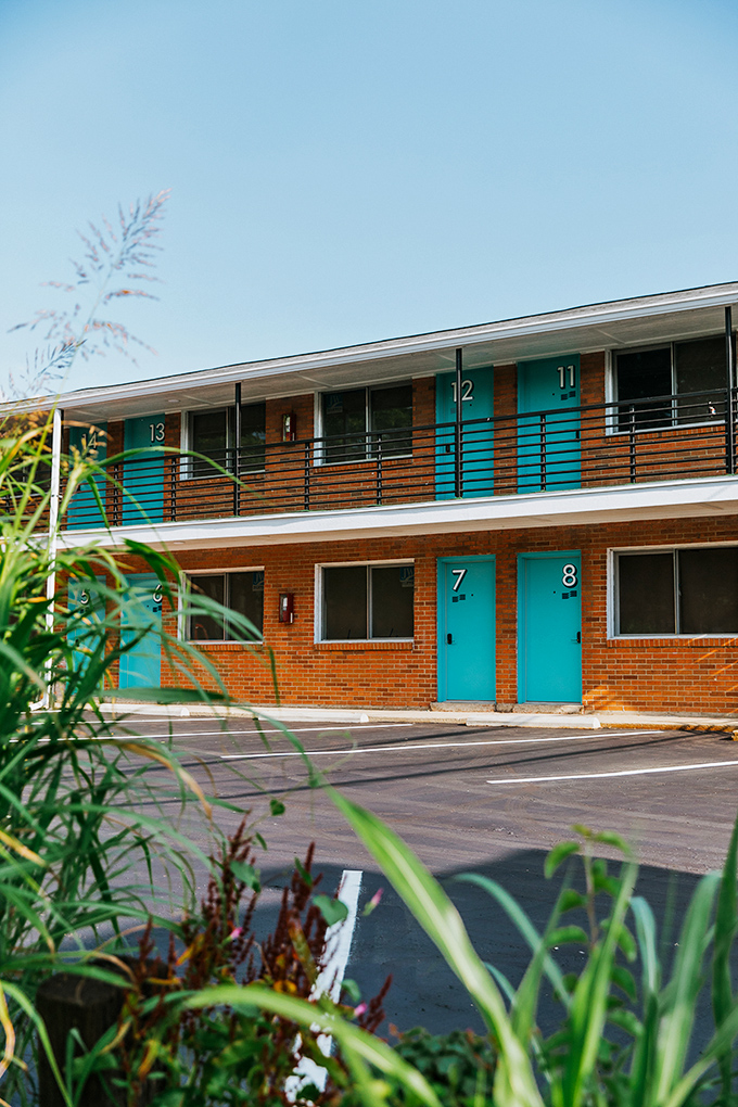 Turquoise doors pop against brick exteriors, each numbered room promising its own slice of mid-century magic.