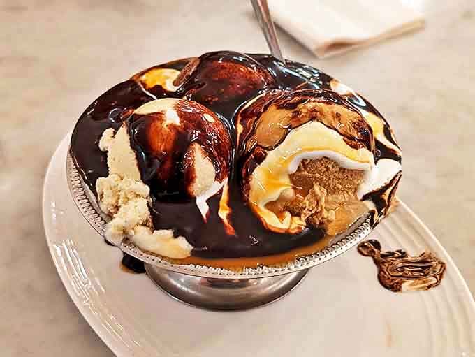 Hot fudge cascades over scoops of vanilla and chocolate, creating rivers of decadence that would make Willy Wonka himself jealous.