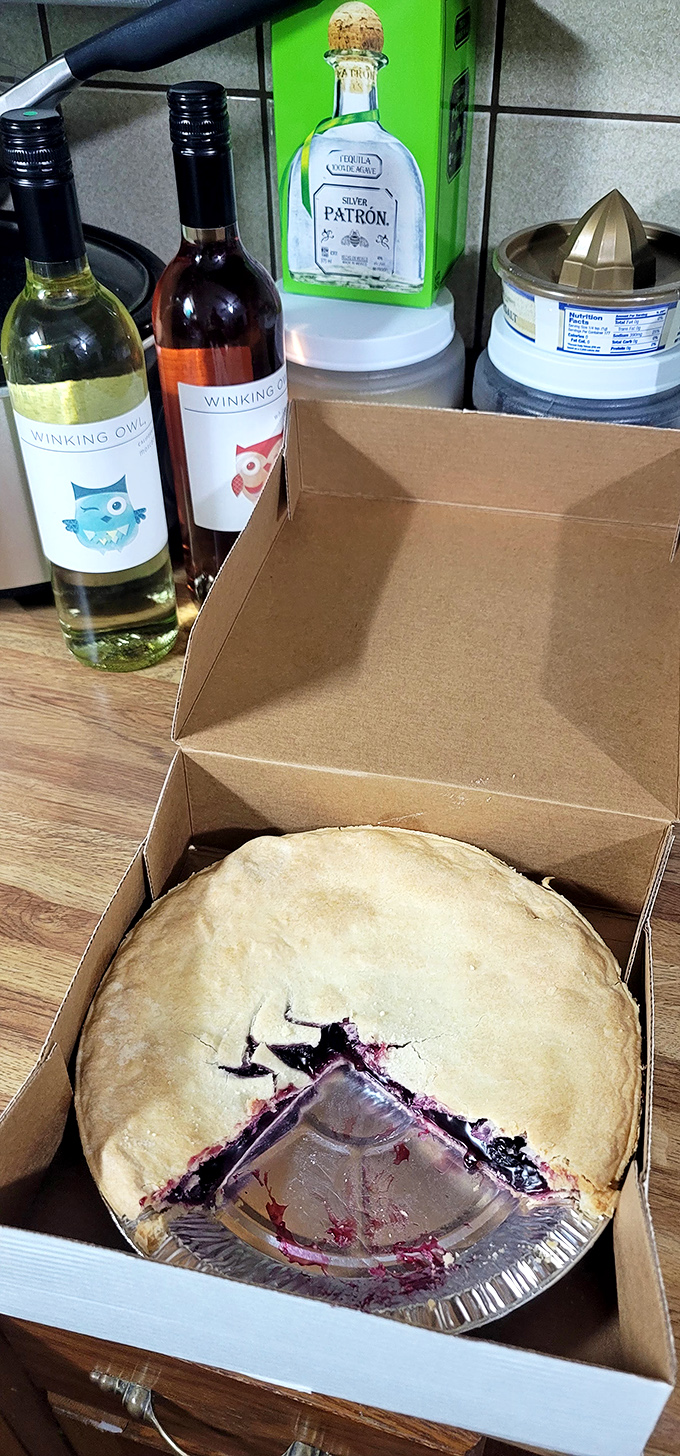 A blueberry beauty being boxed for takeout. Some pies never make it home intact &ndash; the car ride becomes an impromptu picnic with plastic forks.