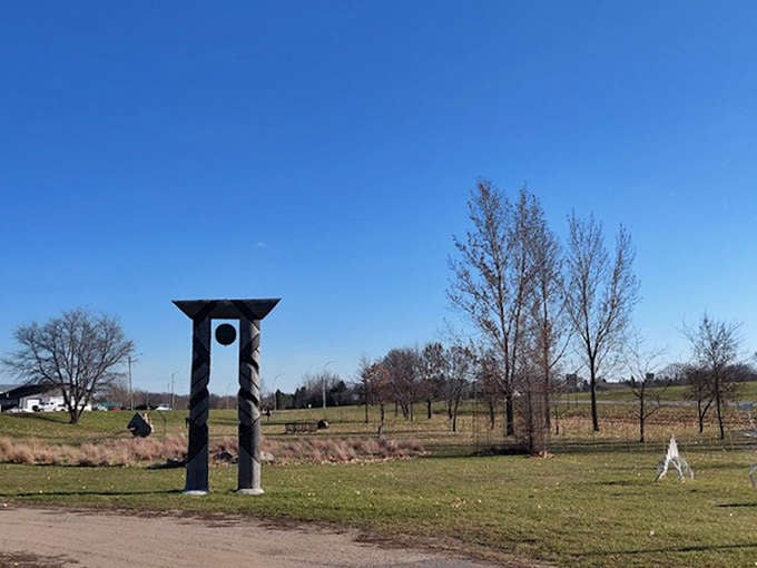 Metal sculptures dot the landscape like mechanical wildflowers, creating an outdoor gallery where farm equipment dreams come true.