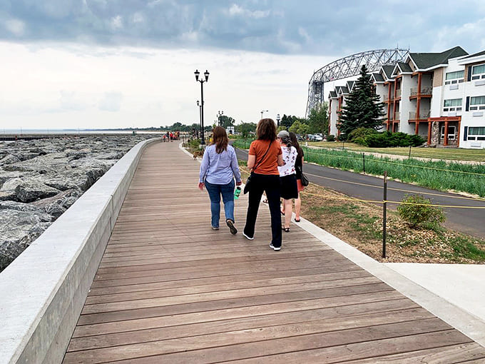 Visitors stroll along the wooden pathway, their conversations punctuated by the soundtrack of lapping waves and distant ship horns announcing maritime arrivals.