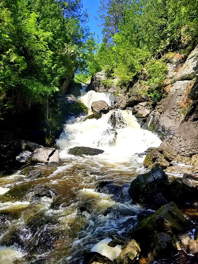 Long Slide Falls lives up to its name, sending water gliding down a natural rock chute through a forest that feels untouched by time.
