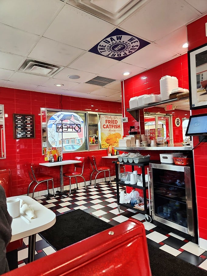 The vibrant red interior of Nicky D's features classic checkered floors and counter seating &ndash; pure nostalgic perfection for burger lovers.