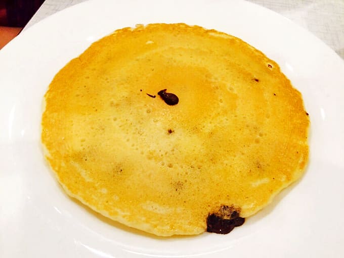 A simple pancake transformed into breakfast art – golden, fluffy, and sporting those perfect little bubbles that promise deliciousness.