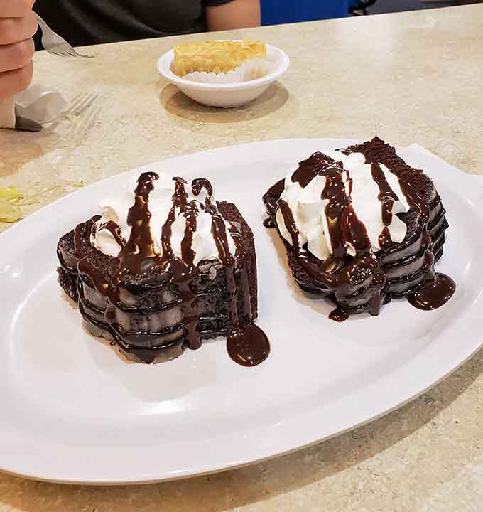 Two chocolate brownies topped with ice cream and drizzled with chocolate sauce, because sometimes restraint is overrated.